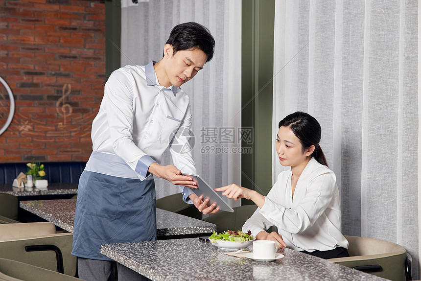 酒店餐饮区的服务人员给顾客点餐形象高清图片下载-正版图片507512173-摄图网