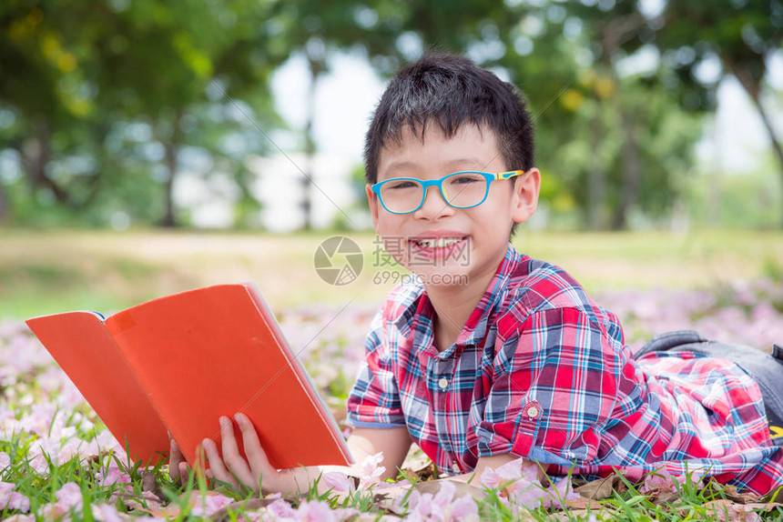 年轻的亚洲男孩在公园看书高清图片下载-正版图片507575866-摄图网