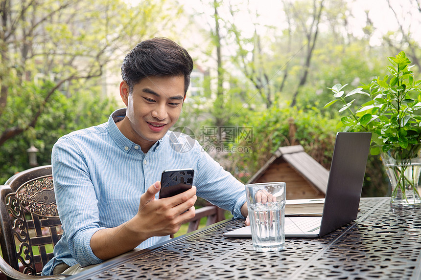 青年男人在院子里看手机高清图片下载-正版图片507650571-摄图网