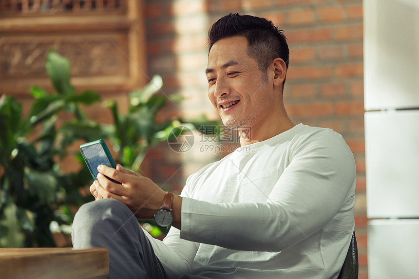 青年男人在家看手机高清图片下载-正版图片507664040-摄图网