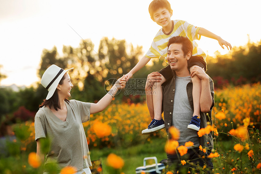 幸福的一家三口站在花丛中高清图片下载-正版图片507679977-摄图网