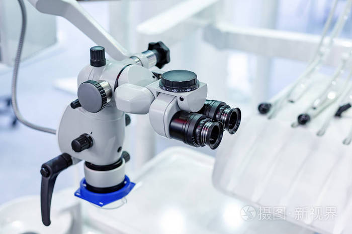 牙科显微镜在现代牙科的背景。医疗设备。旋转双双目牙科手术显微镜照片-正版商用图片063ol9-摄图新视界